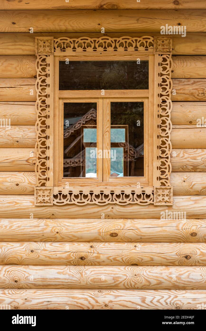 Wooden window with carved plat bands on the wall made of logs Stock ...
