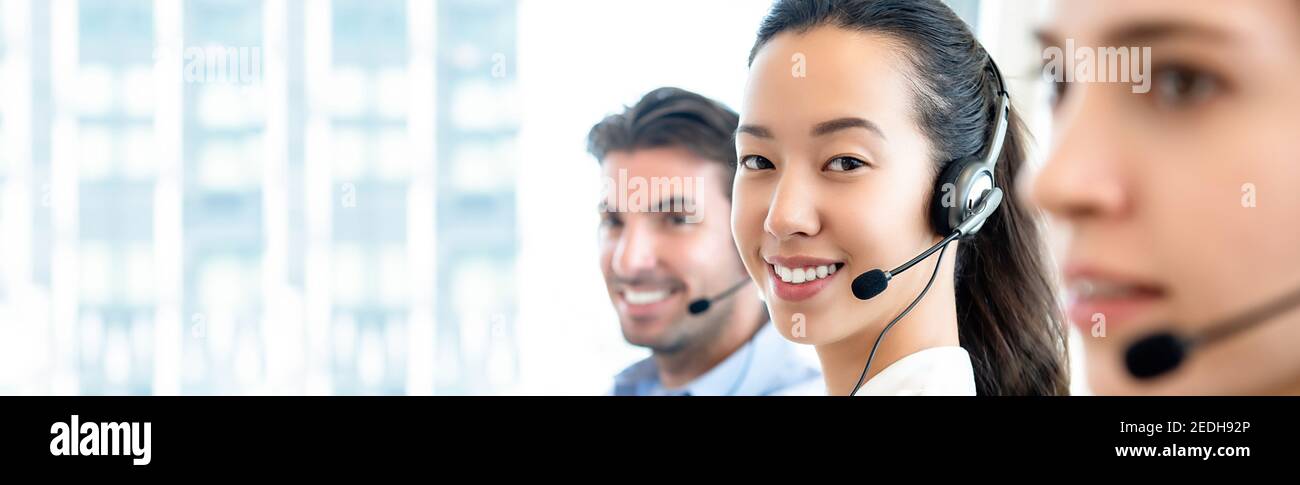 Smiling beautiful Asian woman working in call center office with ...