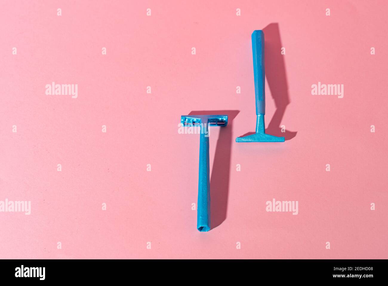 Blue disposable razors on pink paper background Stock Photo - Alamy