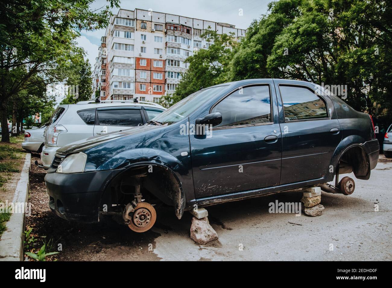 A car without wheels parked on the street. Thieves substituted stones ...