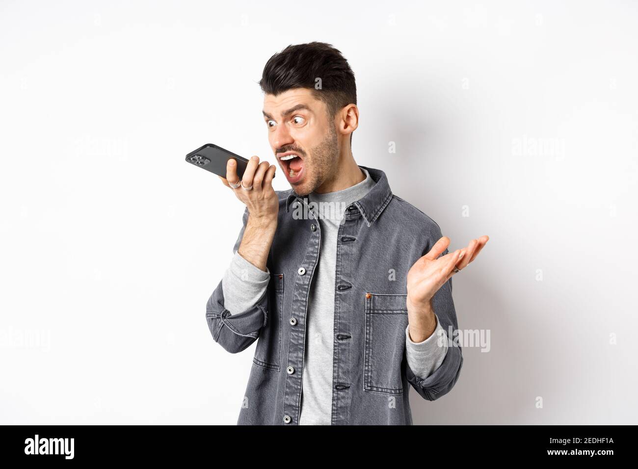 Angry guy shouting at speakerphone, scream on mobile phone, leaving ...