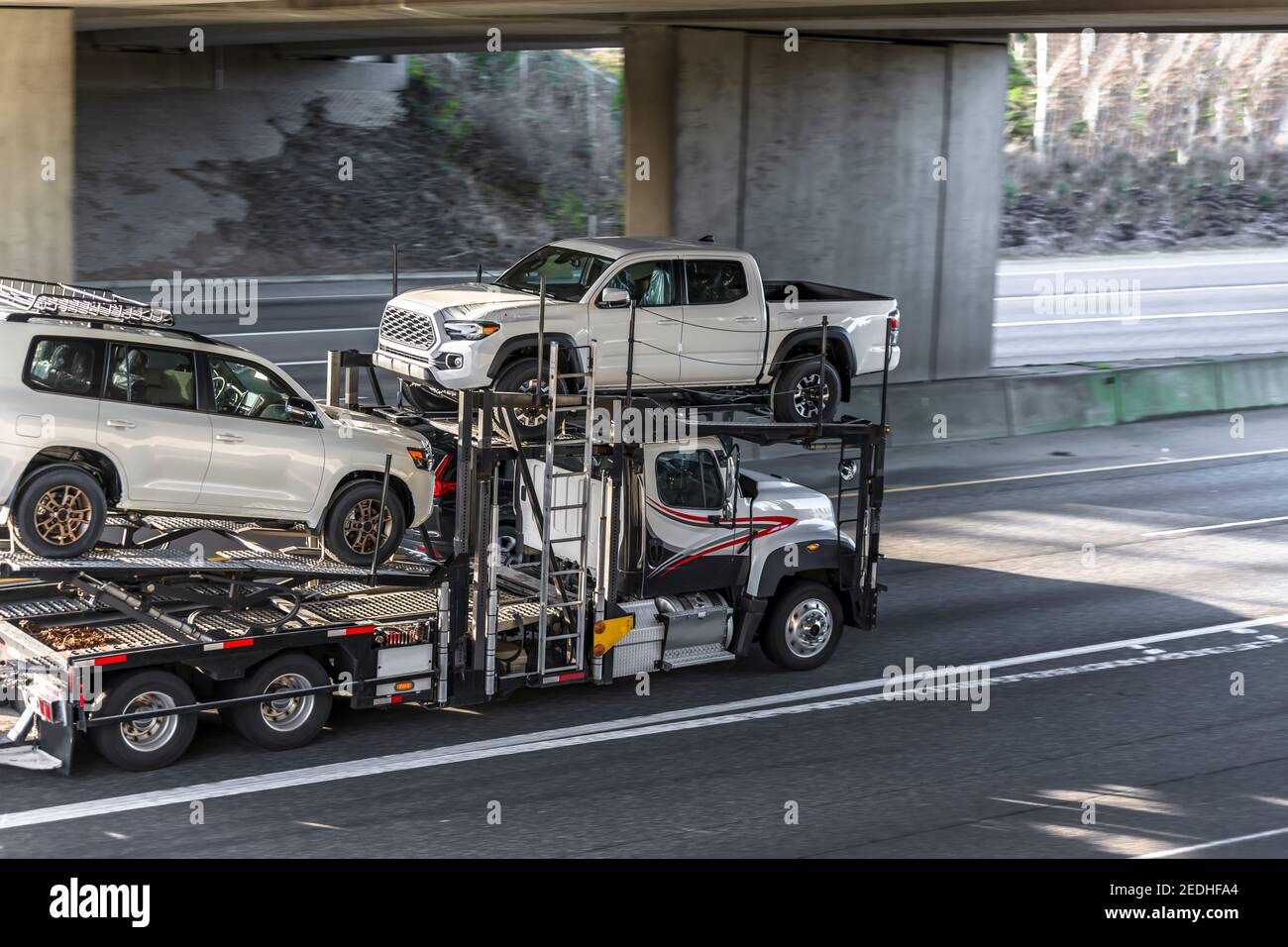 Big rig white car hauler semi truck transporting cars on the two level ...