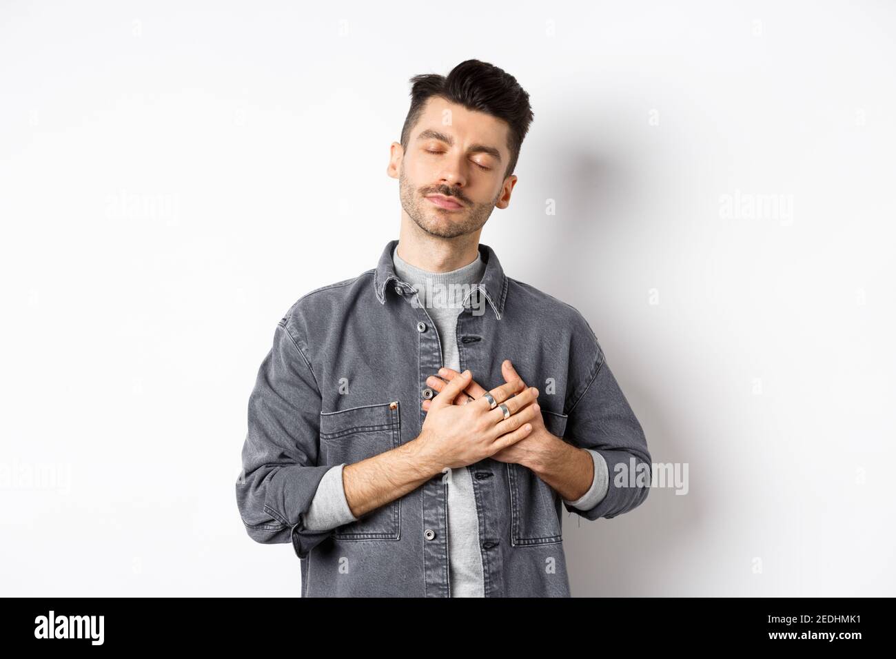 Nostalgic man hold hands on heart, remember tender memories, standing ...