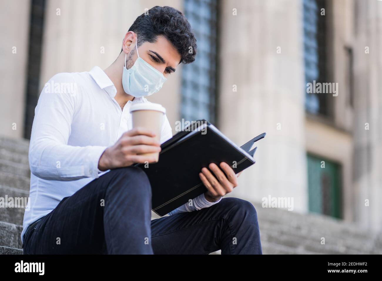 Business man reading files outdoors Stock Photo - Alamy