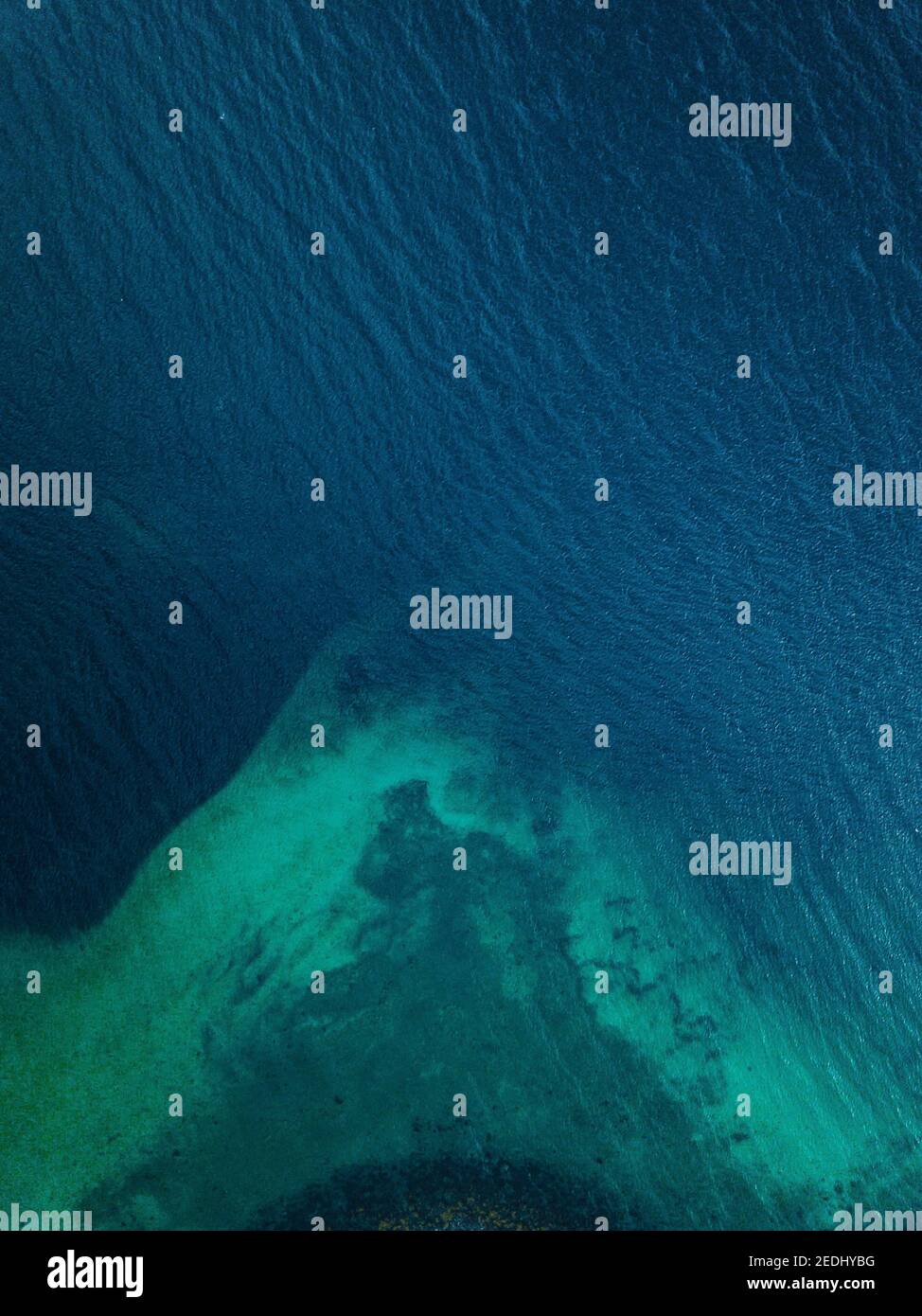 Vertical overhead shot of cliffs underneath the blue water Stock Photo ...