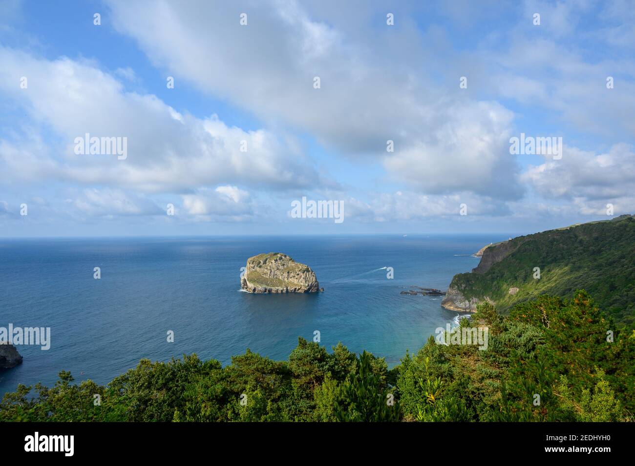 Aerial shot of a forested hill on the coastline near the blue sea Stock ...