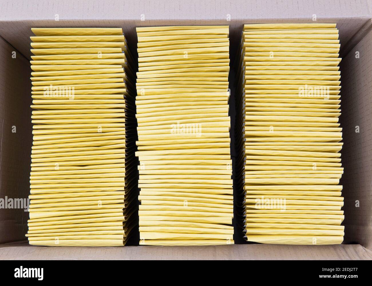 Top view of three stacks of yellow mail envelopes neatly packed in a ...