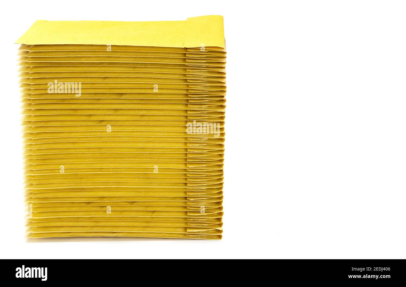 Stack of yellow padded envelopes isolated on white. Side view, copy ...