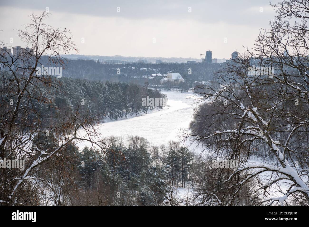 Frozen river Neris in Vilnius, Lithuania, with city and forest on ...