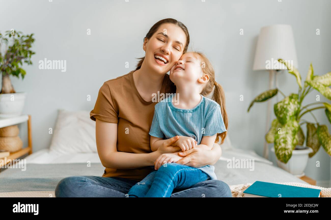 A nice baby girl and her mother enjoy sunny morning. Good time at home ...