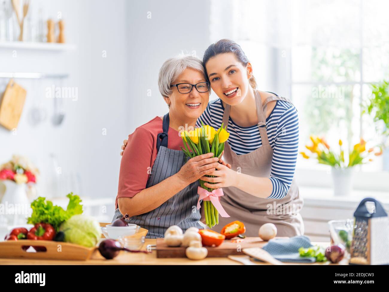 Happy family in the kitchen. Mother and her adult daughter are ...