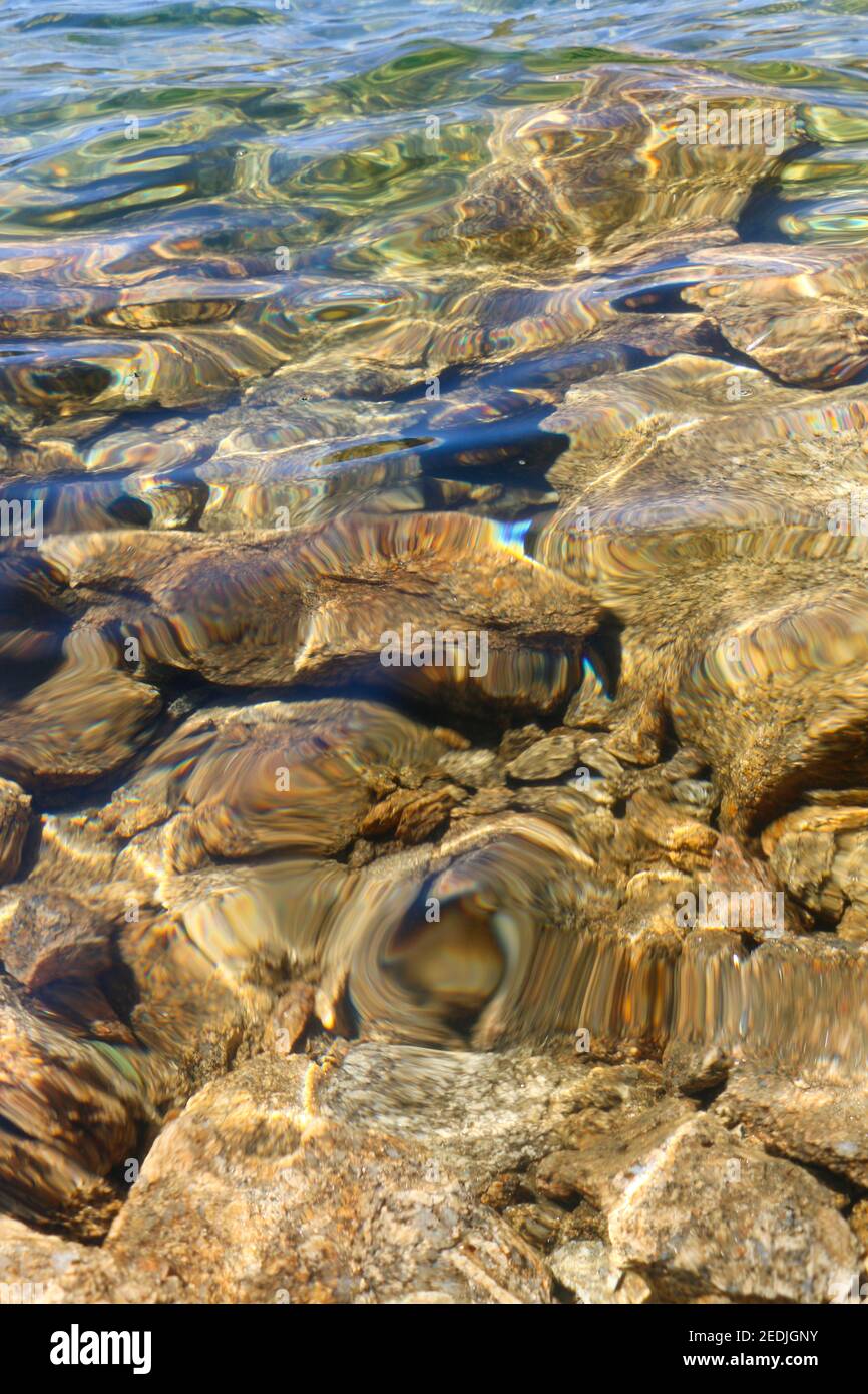 Detail of crystal clear water light reflection on stone underground ...