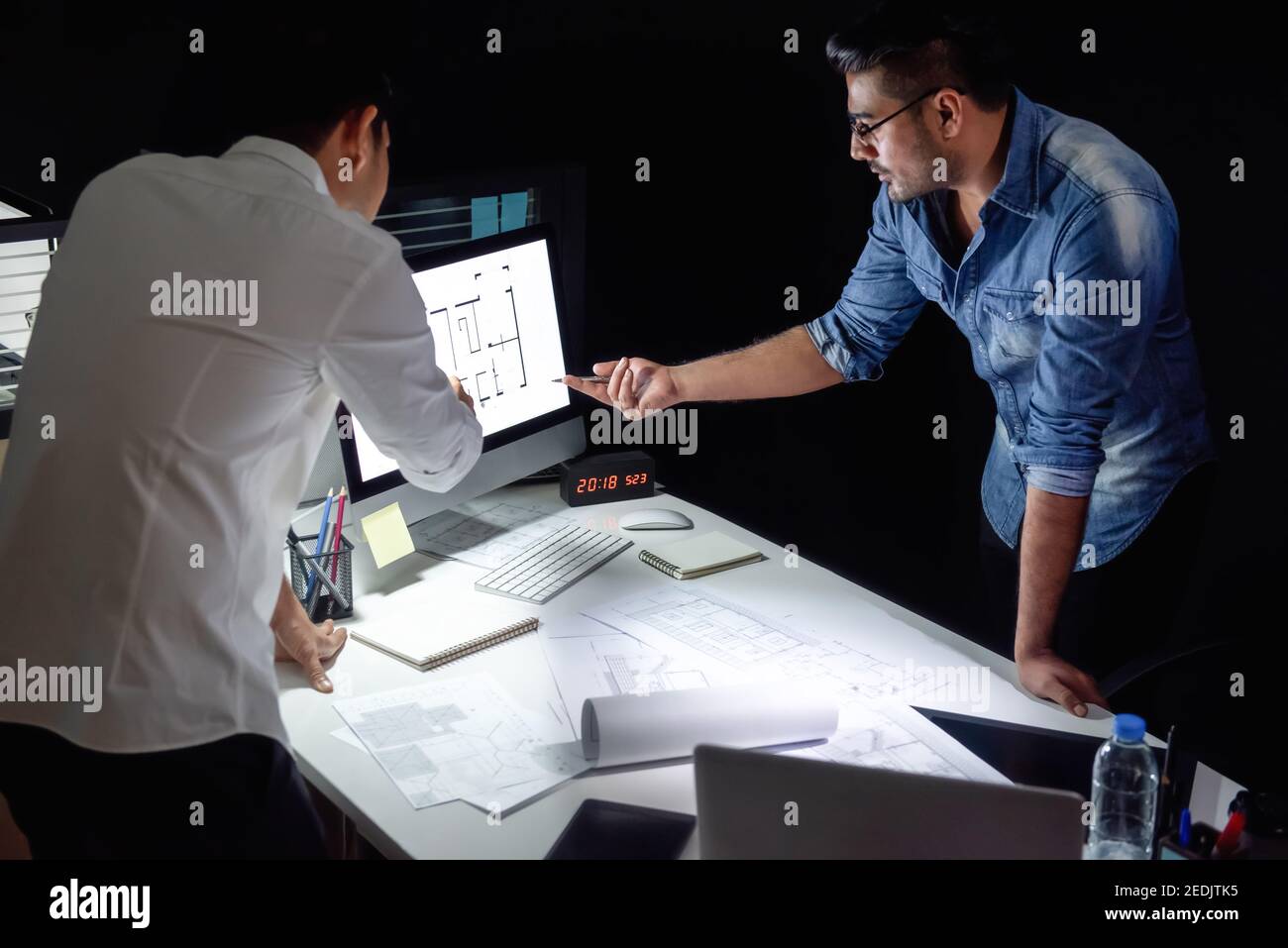 Asian architect team staying late at night in office discussing floor ...