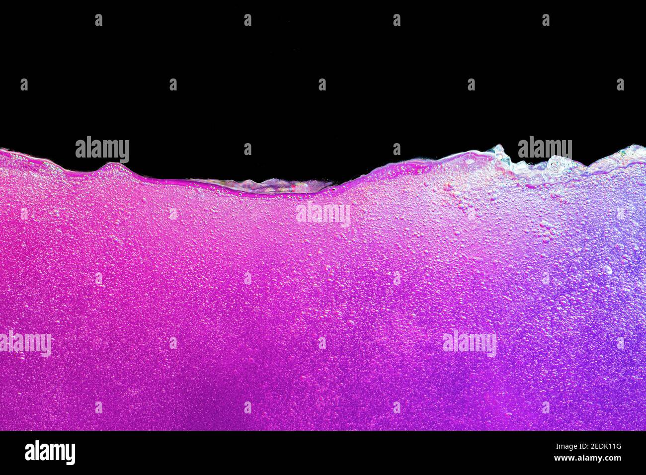 Pink bubbly boiling water against black background Stock Photo - Alamy