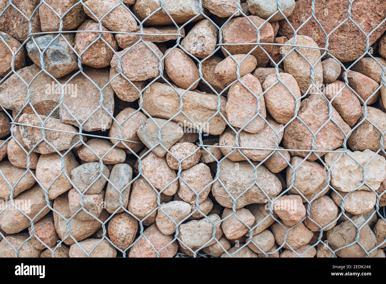 Cobblestone in reinforced mesh - decorative wall Stock Photo - Alamy