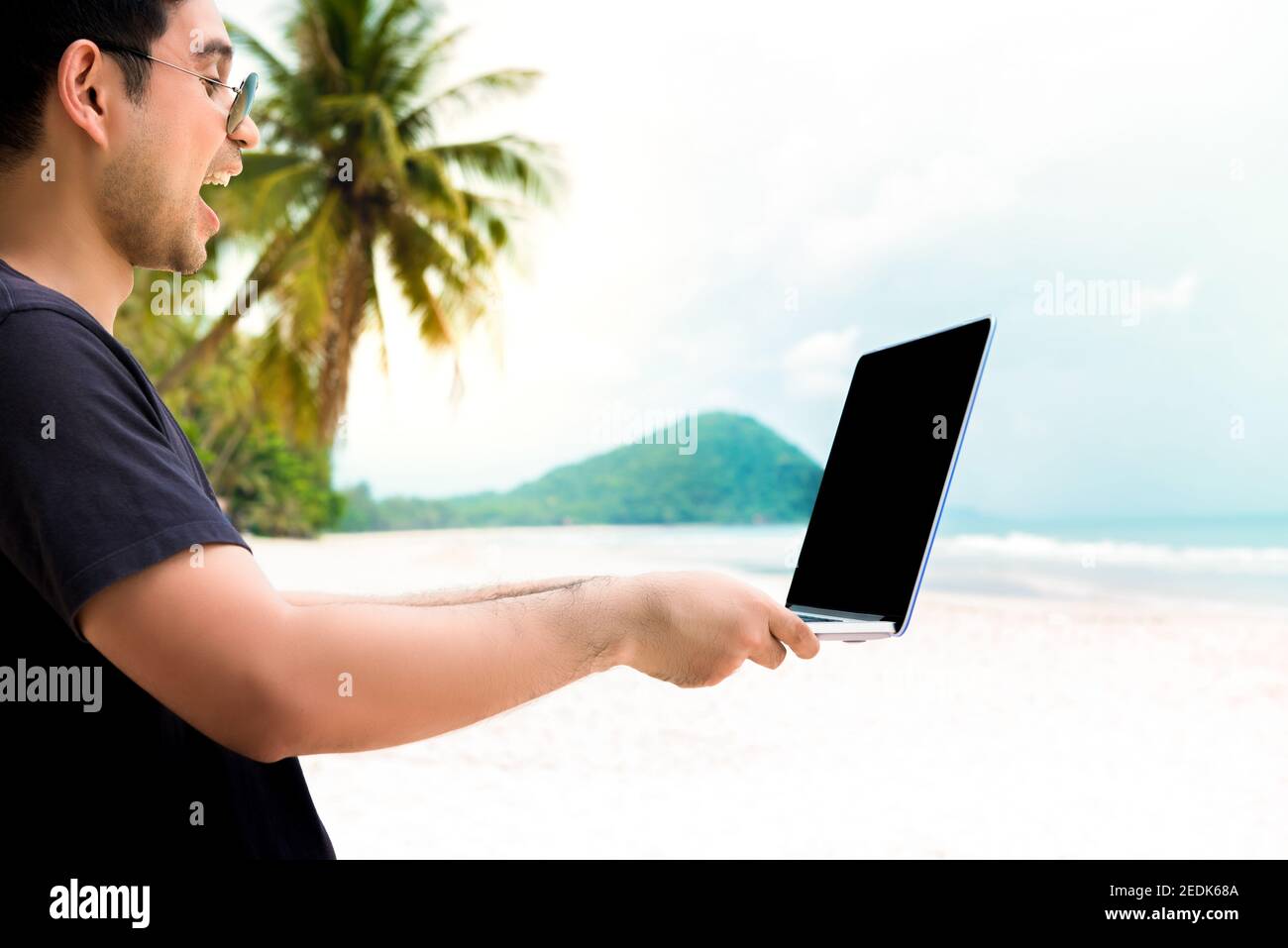 Happy casual man enjoying surfing internet with laptop computer at the ...