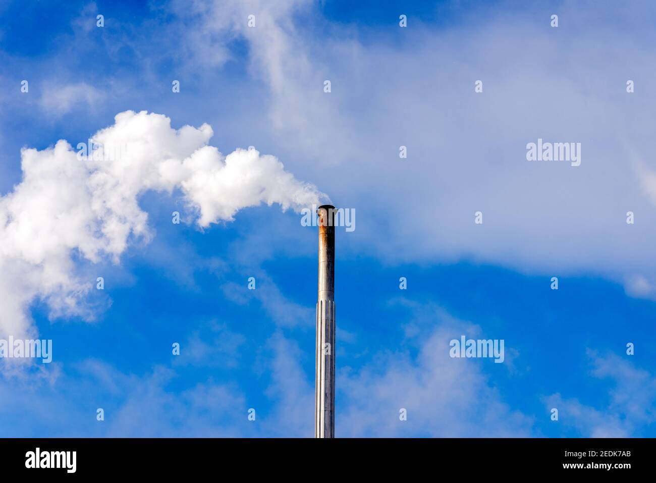 One Industrial smoke pipe from chimney on blue cloudy sky.White smoke ...