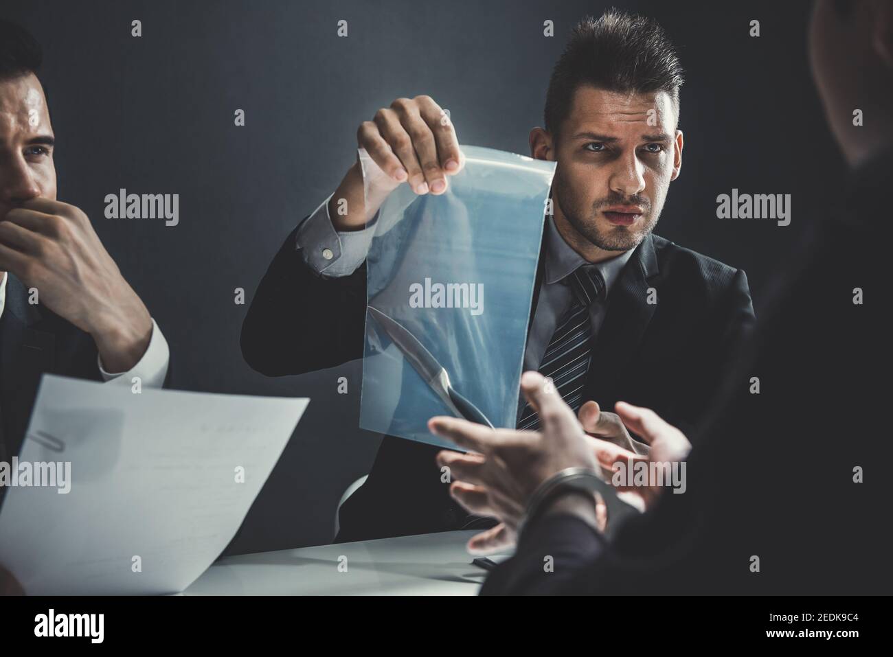Officer in interrogation room showing a knife as a murder evidence for ...