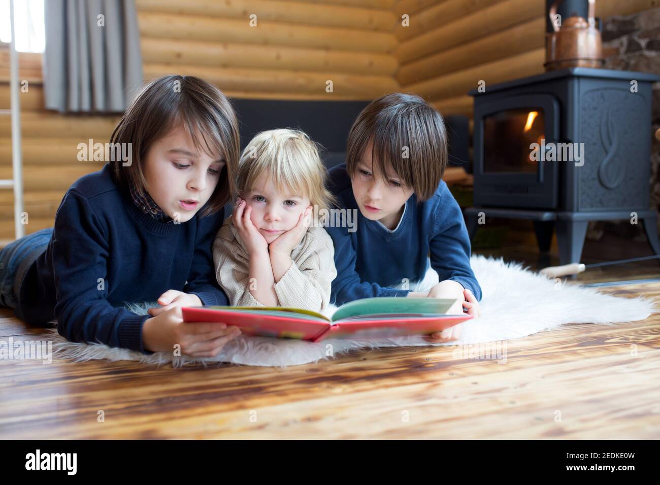 Three sweet children, siblings lying on the floor in little fancy ...
