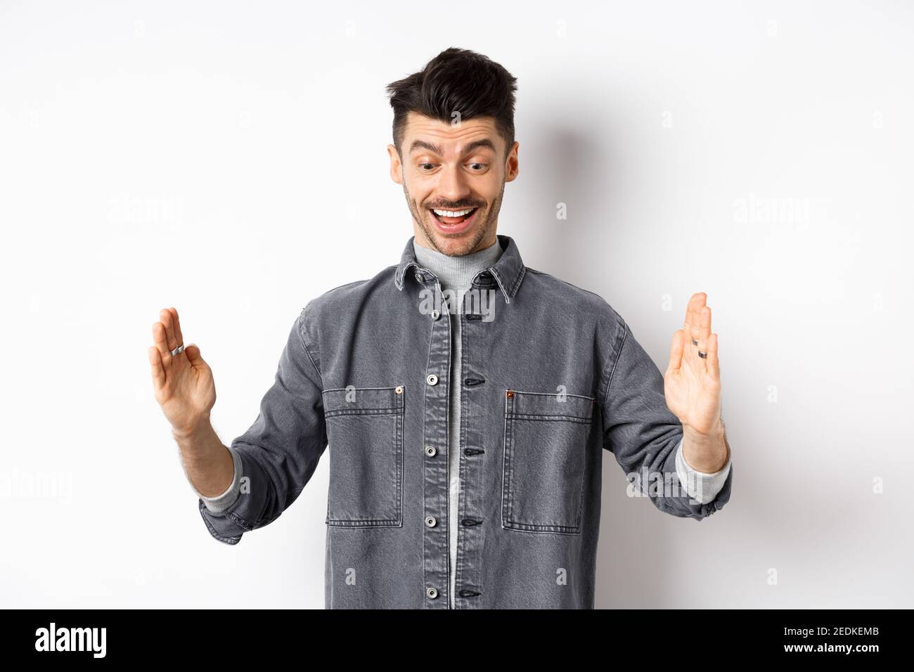 Excited caucasian man showing big size object, shaping large thing and ...