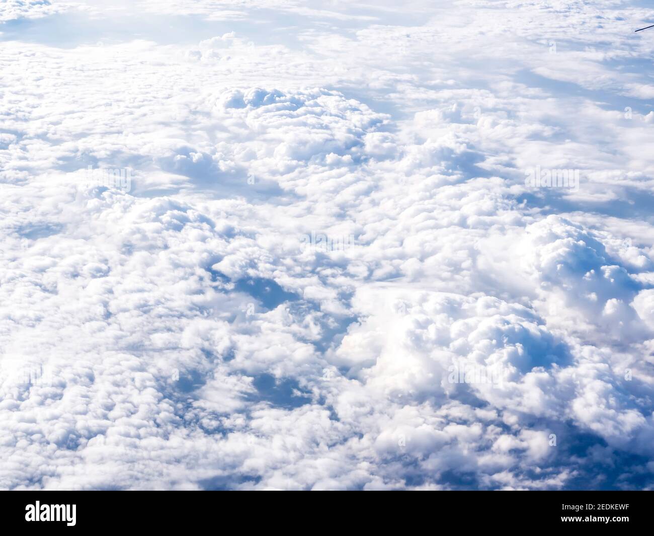 Above the cloud, amazing sky view from airplane window. Beautiful cloudscape with fluffy cloudy ...