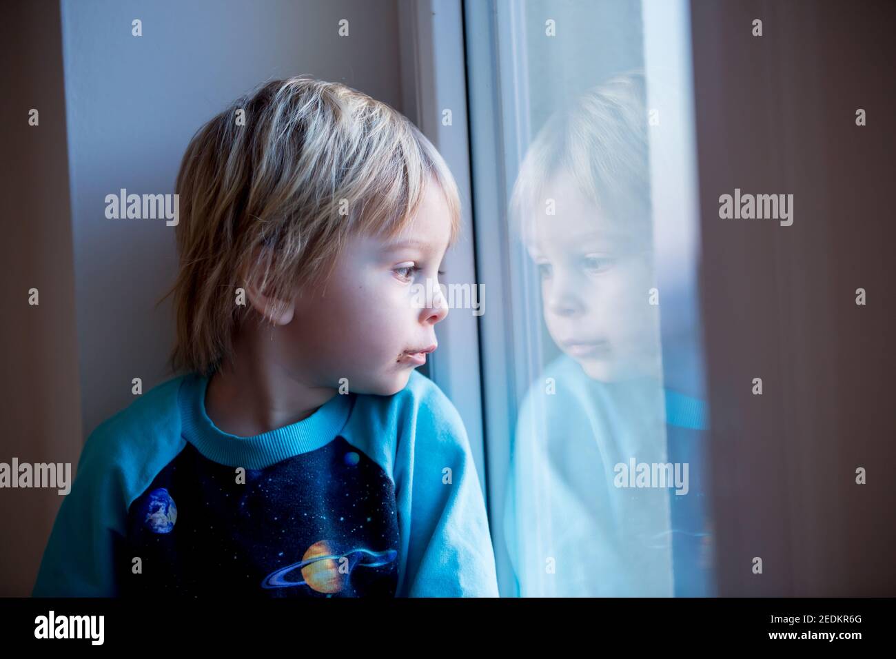 toddler child, sitting on the window on sunset, looking out Stock Photo ...