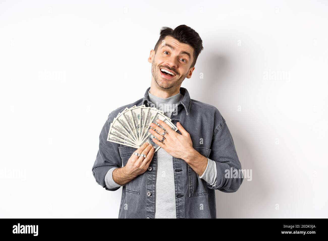 Happy smiling guy making money, hugging dollar bills with pleased ...