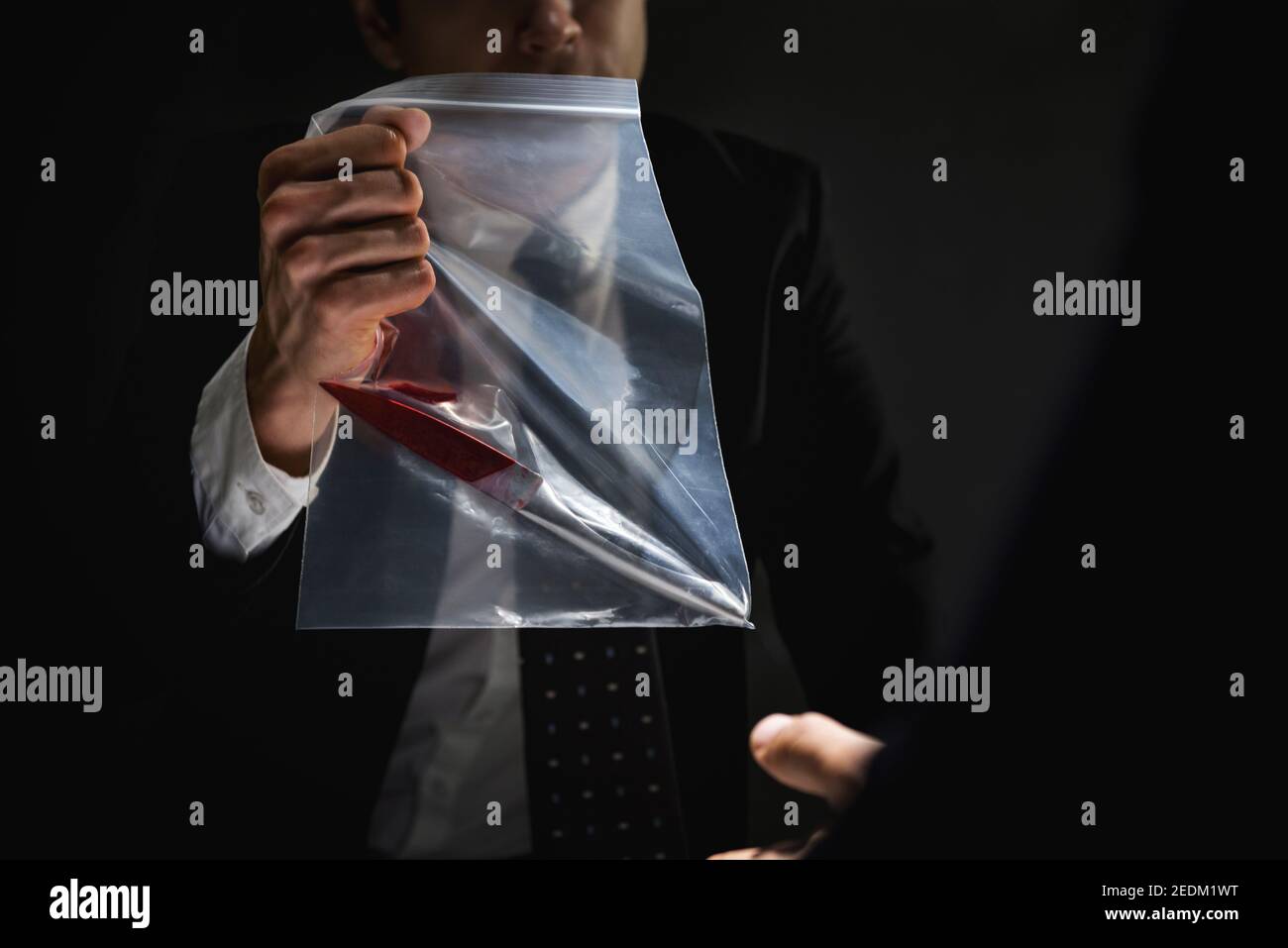 Police in interrogation room showing a knife with blood as a murder ...