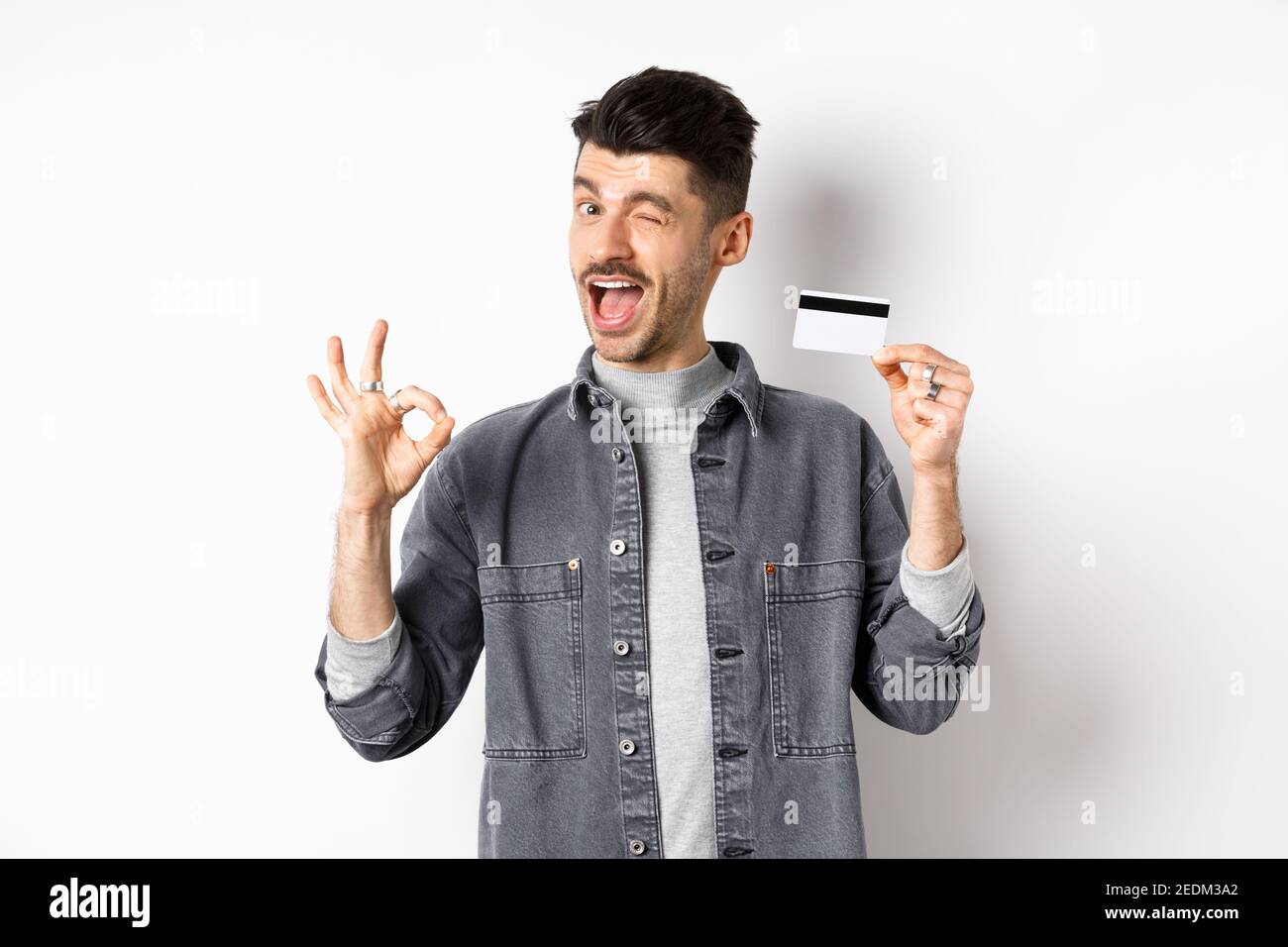 Very good. Smiling guy with plastic credit card showing okay sign ...