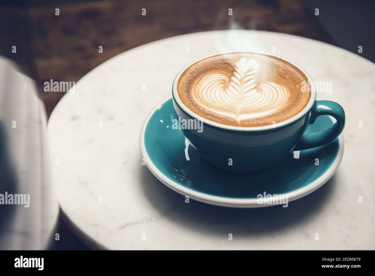 Hot fresh brewed coffee with Rosetta latte art pattern in blue ...
