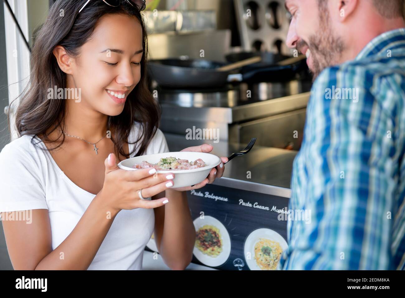 Young woman and friend smiling with pleasure after getting food that ...