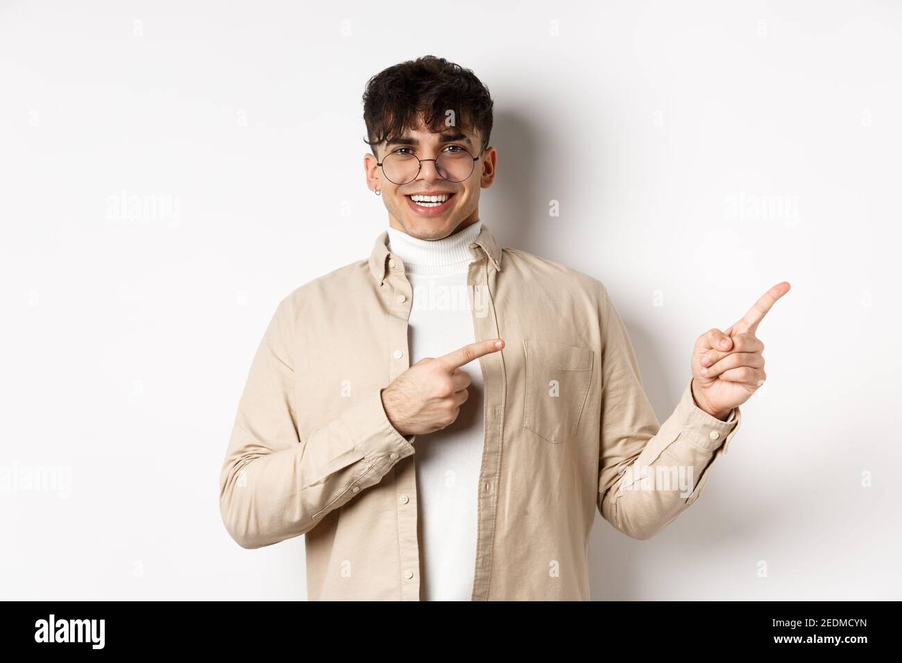 Proud and happy young man in glasses showing logo, pointing fingers at ...