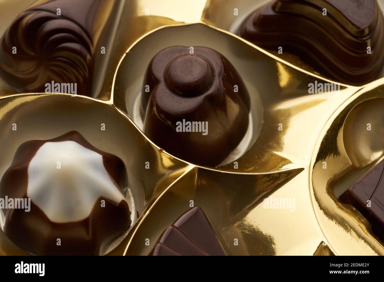 Several assorted chocolates in a yellow packing box Stock Photo - Alamy