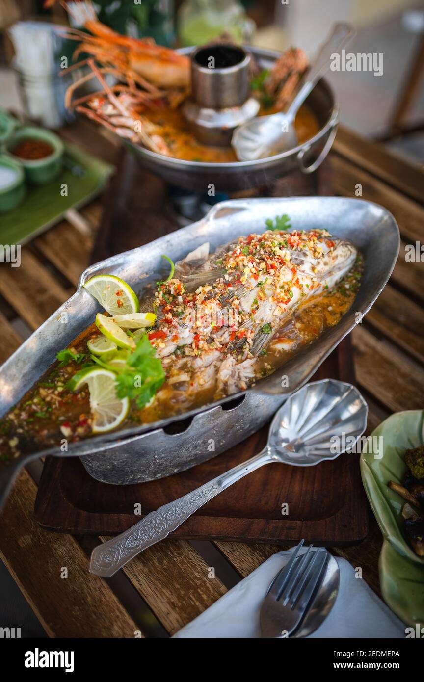 Steamed hammour fish with lime pepper and various food ingredients on a ...