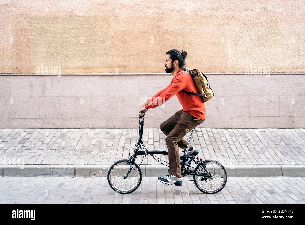 Stock photo of bearded man riding his detachable bike in the street ...