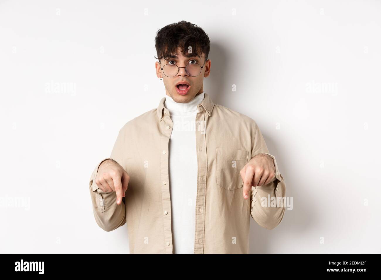 Shocked attractive young man showing something awesome, drop jaw and ...