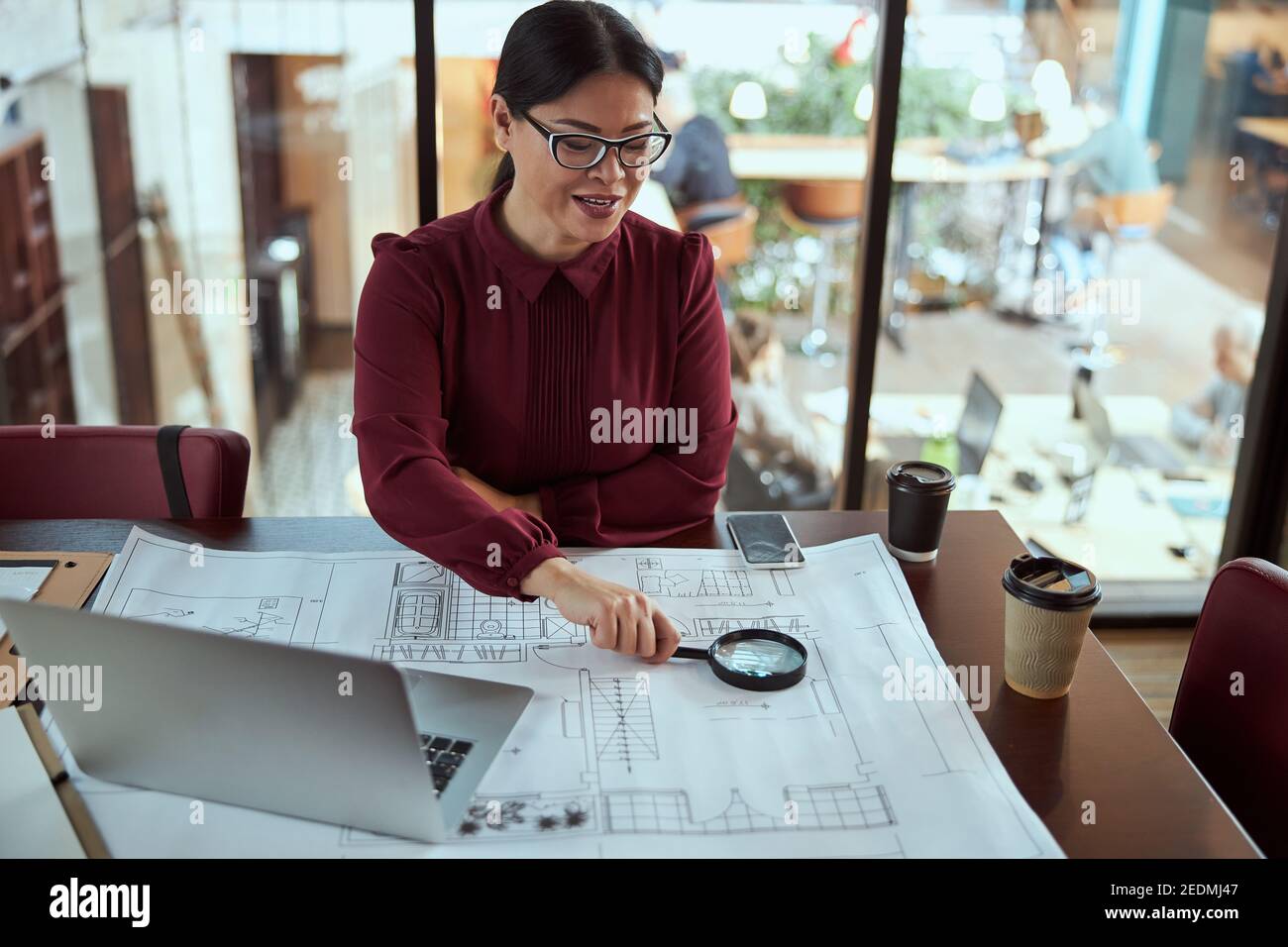 Cute Asian woman using magnifying glass during work Stock Photo - Alamy