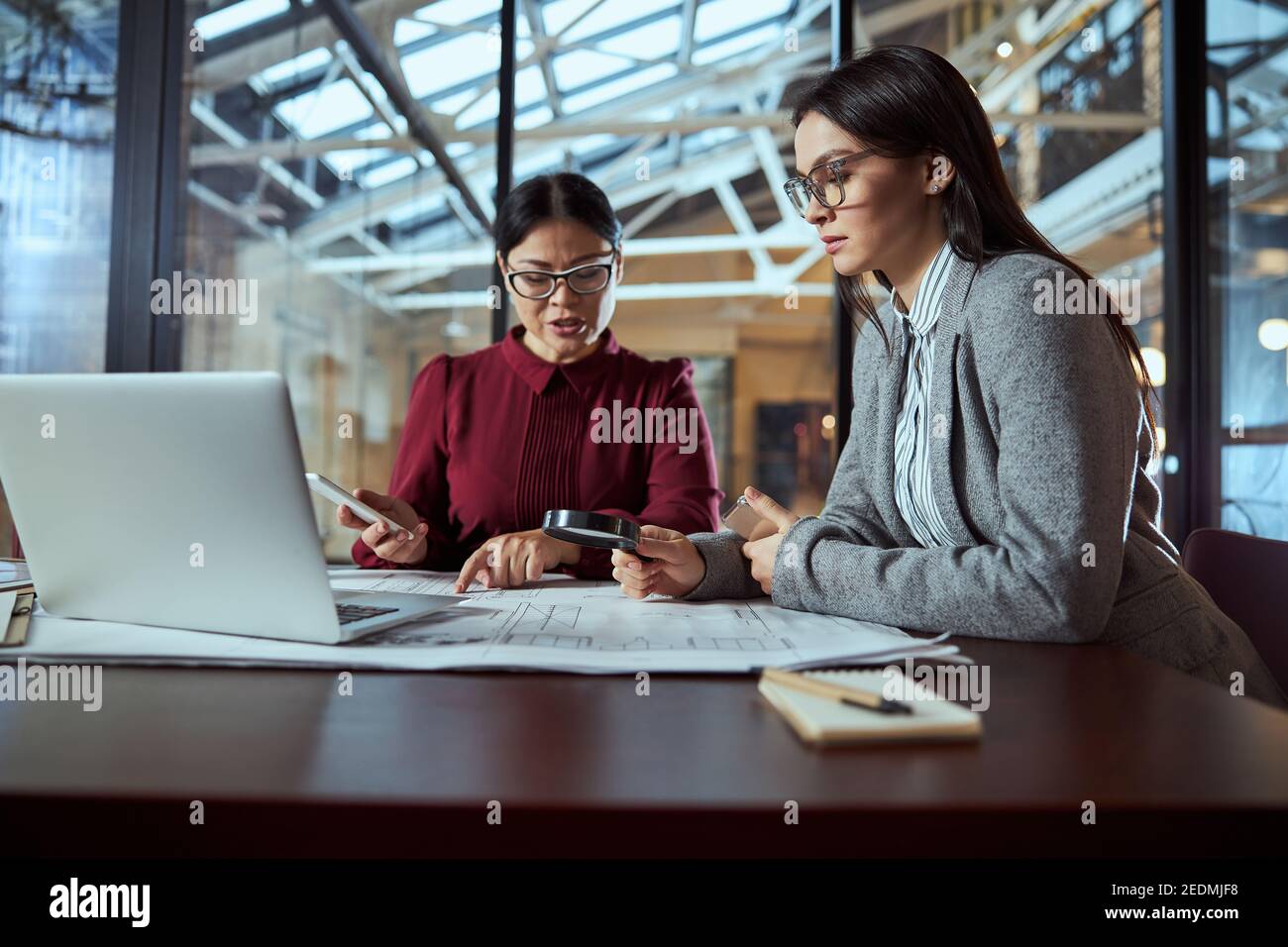 Busy brunette woman working at project in team Stock Photo - Alamy