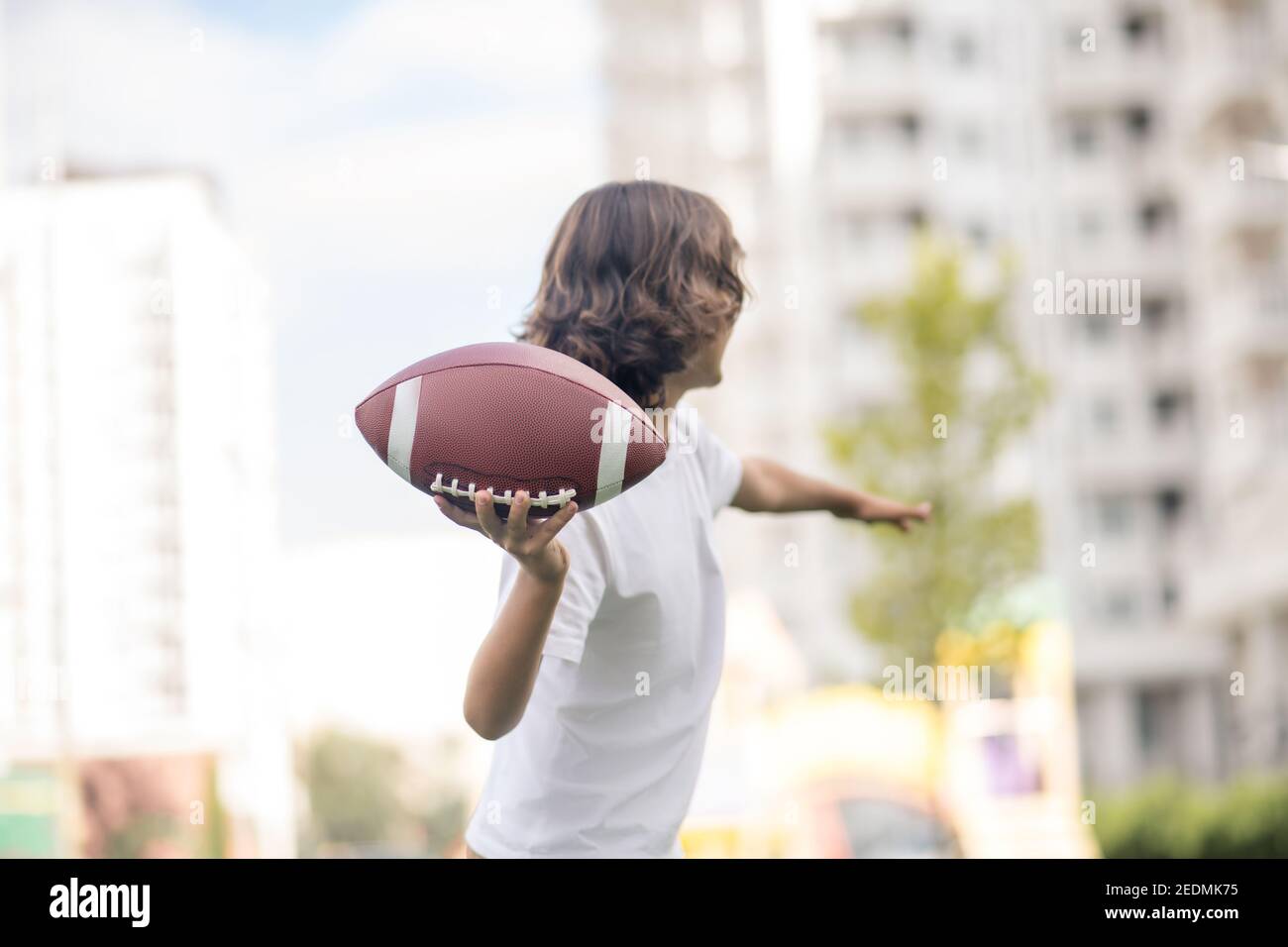 A boy in a white tshirt throwing a ball Stock Photo - Alamy