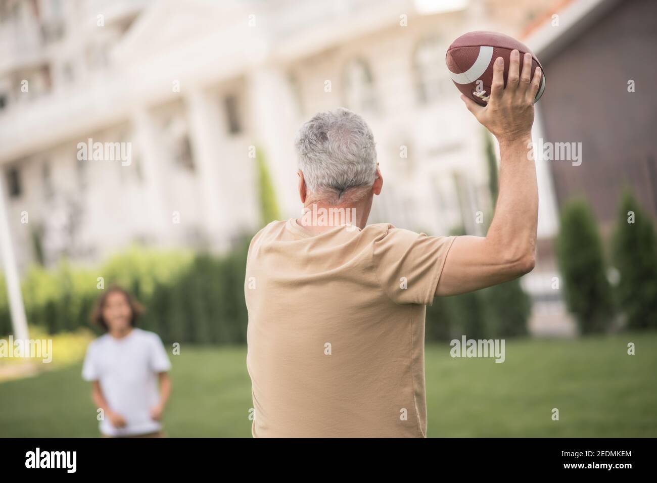 Dad throwing a ball while playing with his son Stock Photo - Alamy