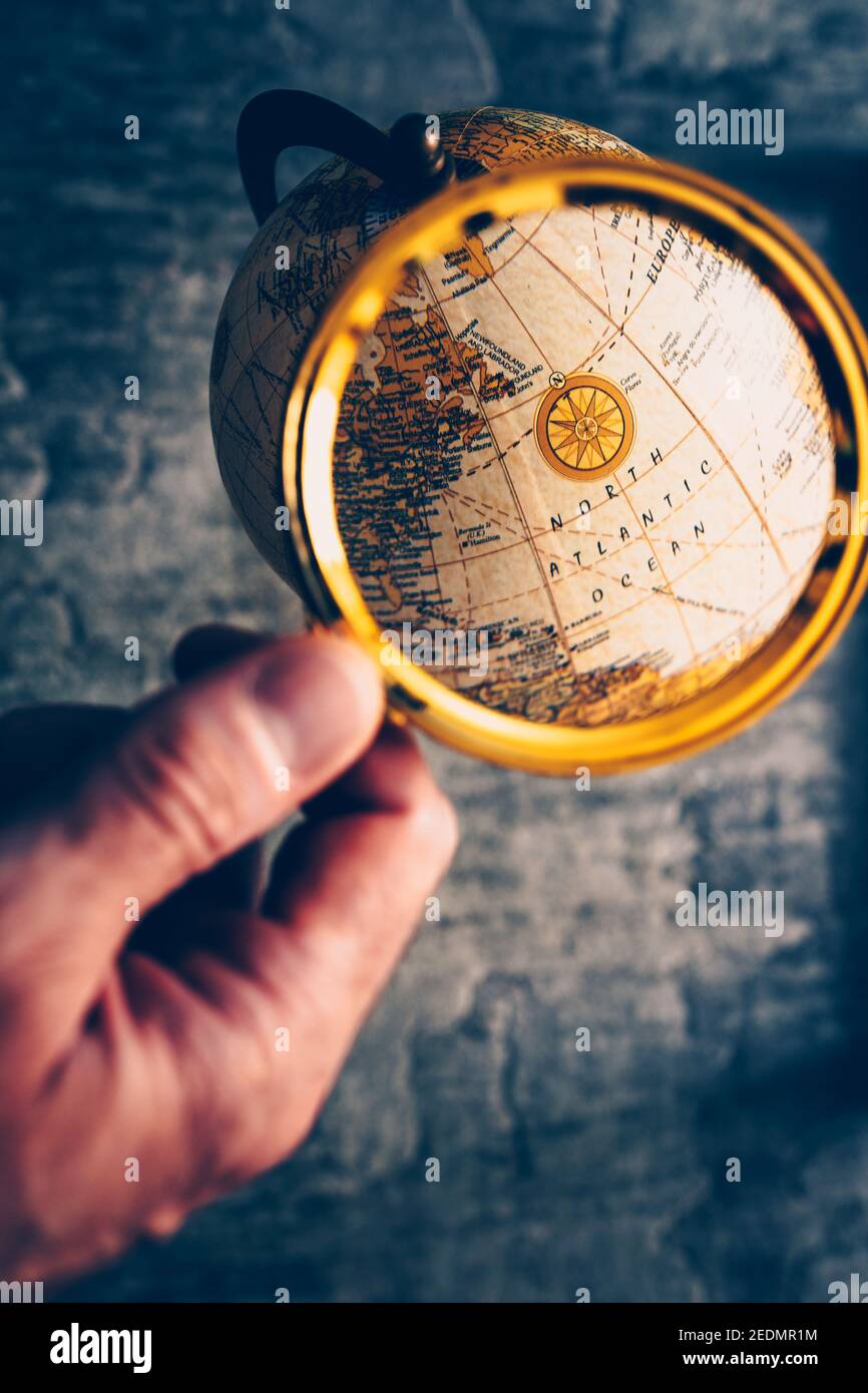 Exploring planet Earth on a geographic globe through a magnifying glass ...