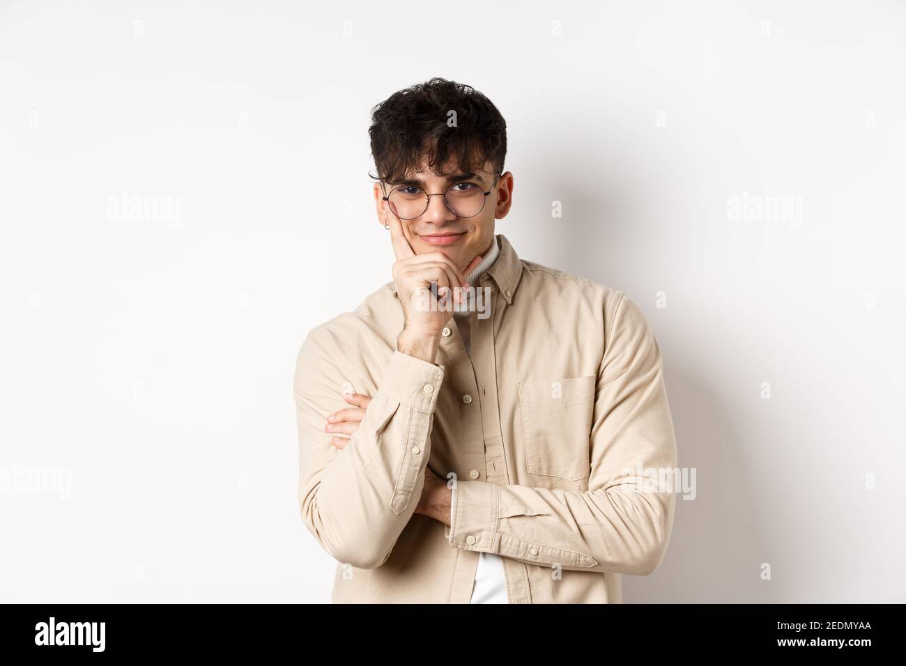 Cunning young man watching something interesting happen, lean face on ...