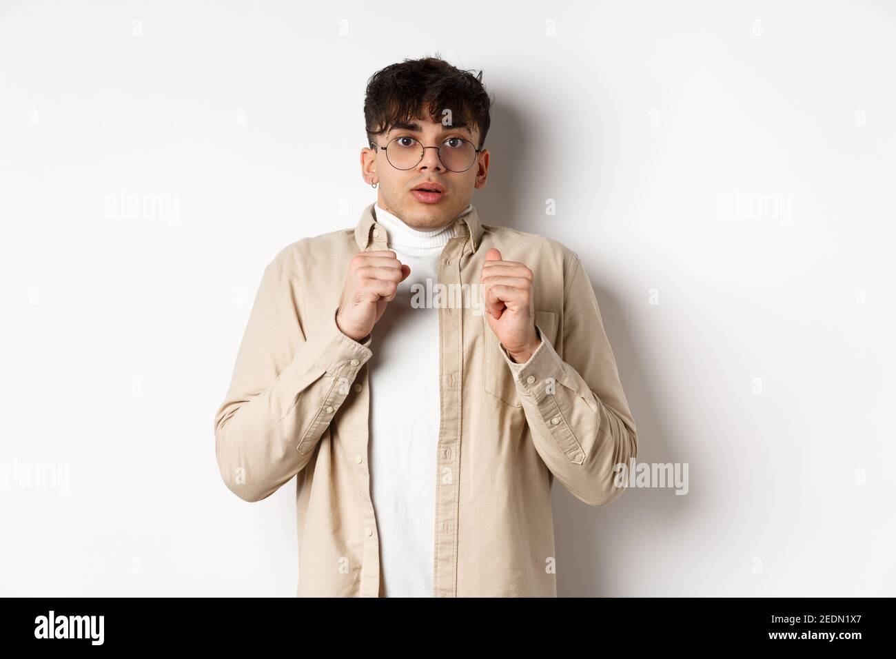 Startled man freeze from fear, gasping and looking scared at camera ...
