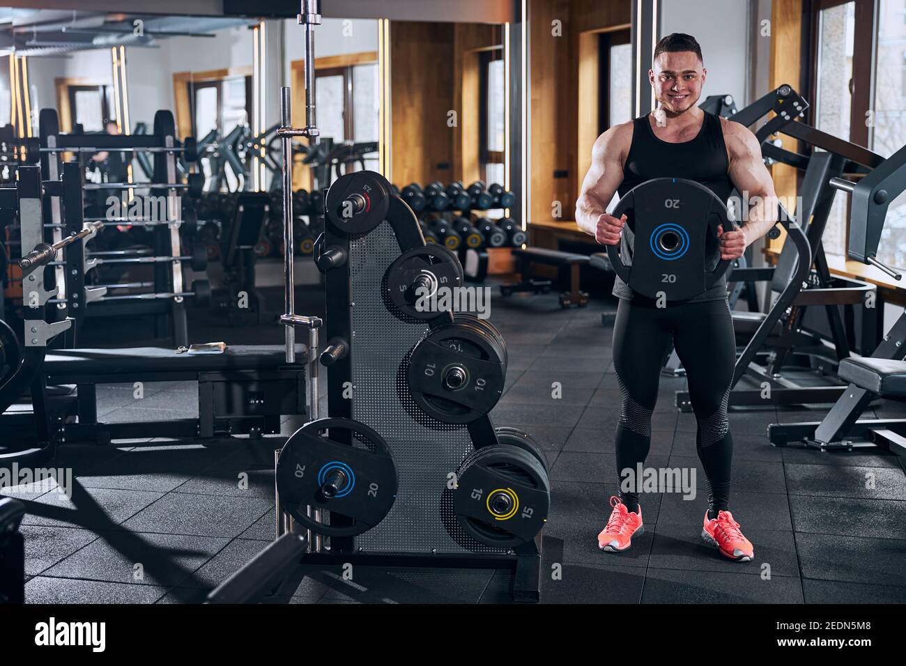 Happy young man enjoying weihgt lifting in gym Stock Photo - Alamy