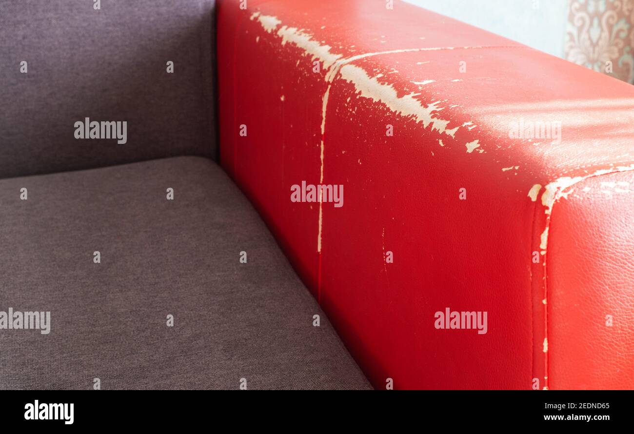 Torn and battered leather back of the sofa. Poor quality leather ...