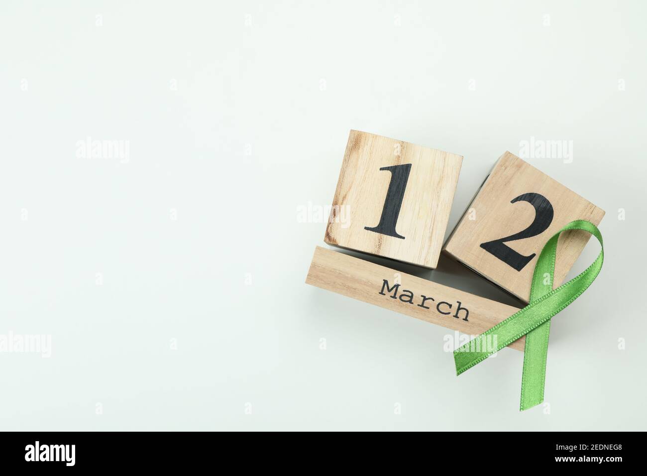Wooden calendar with 12 march and green awareness ribbon on white ...