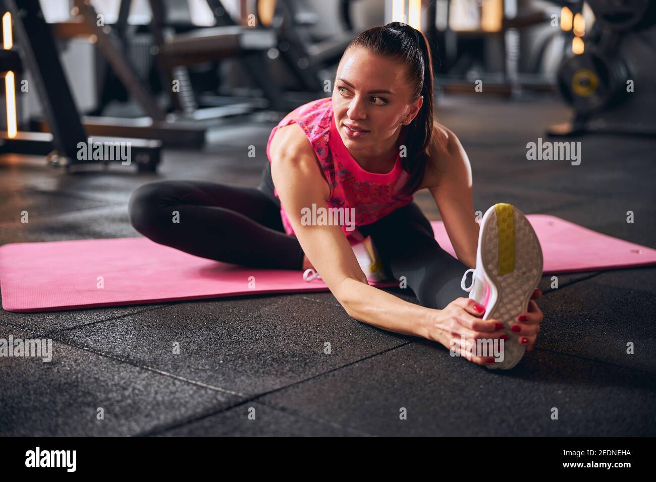 Serene fit woman finishing training with stretching Stock Photo - Alamy