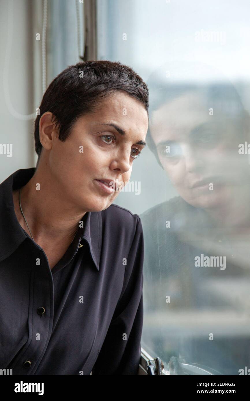 Woman leaning against glass window hi-res stock photography and images ...
