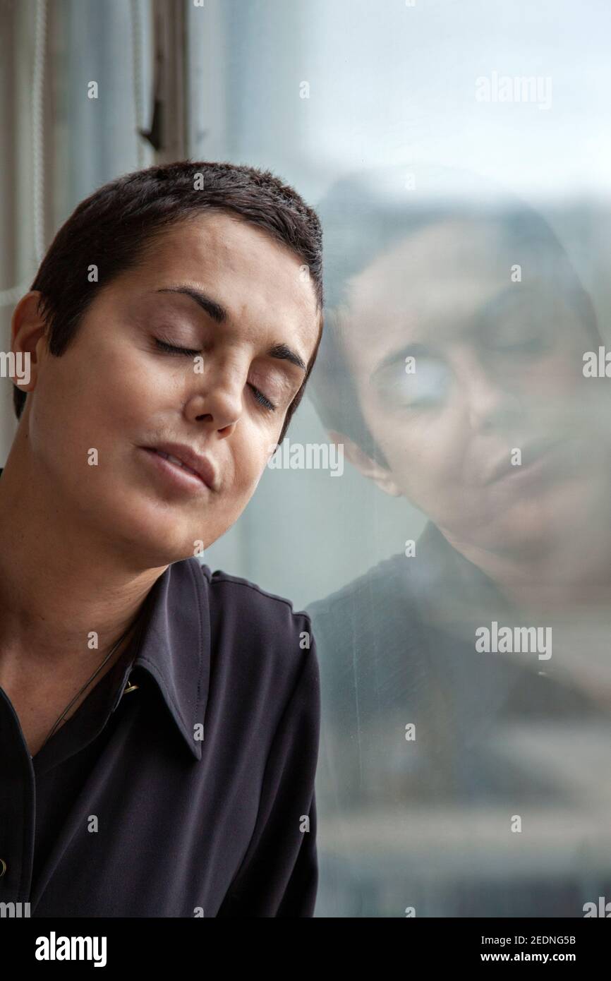 Woman Short Hair Leaning Against Window Stock Photo - Alamy