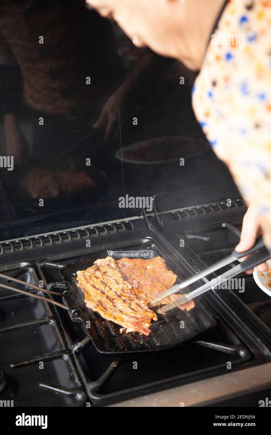 Man Grilling Meat on Stove Stock Photo - Alamy